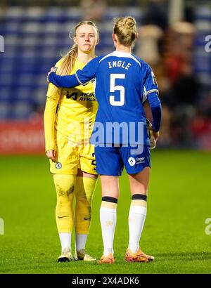 Chelsea goalkeeper Hannah Hampton (left) clears the ball under pressure ...