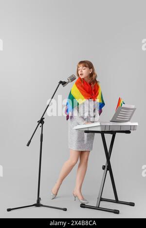 Female singer with LGBT flag and microphone on light background Stock ...
