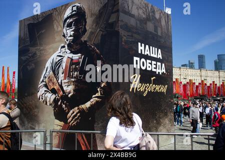 A woman observes a poster depicting a Russian serviceman at a newly ...