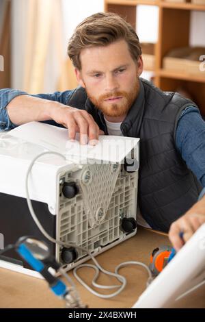 Young repairman fixing and repairing microwave oven Stock Photo - Alamy