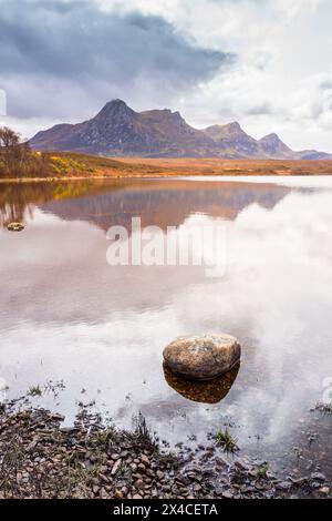 The mountain range of Ben Loyal reflected in the still waters of Lochan ...