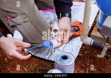 Glue applied to pvc pipe by plumber before it is glued Stock Photo - Alamy