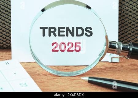 2025 trend concept. TRENDS 2025 through a magnifying glass on a white ...