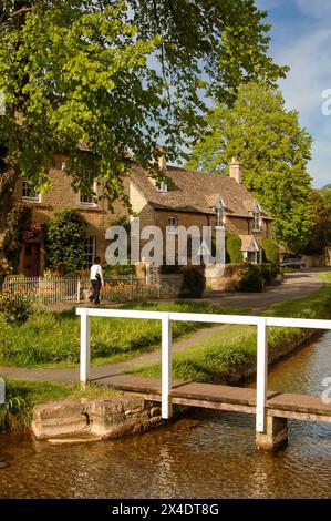 Stone cottages line the River Eye in the pretty Cotswold village of ...