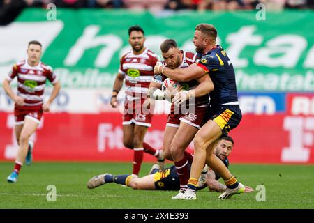 Kaide Ellis of Wigan Warriors is tackled during the Betfred Super ...