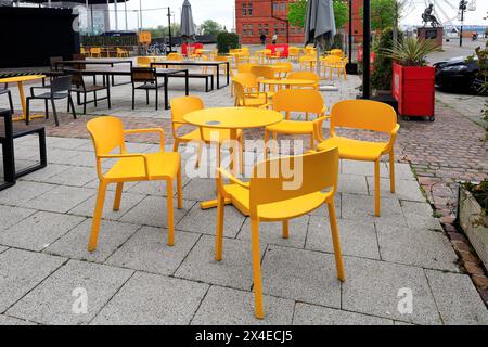 Inviting bright yellow tables and chairs at an outdoor seating area ...