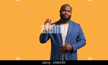 African american man reluctantly doing salutation hand gesture ...