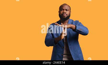 Portrait of assertive BIPOC man asking for timeout, doing hand gestures ...