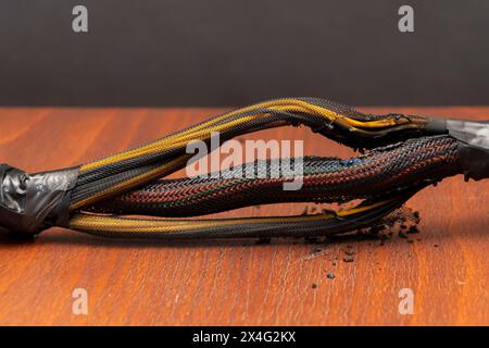 Burnt and melted wires smoke on a dark background. A short circuit in ...
