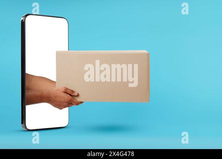 Courier passing parcel through smartphone on dark beige background ...
