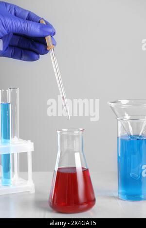 Scientist dripping liquid into a flask Stock Photo - Alamy