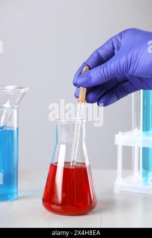 Scientist dripping liquid into a flask Stock Photo - Alamy