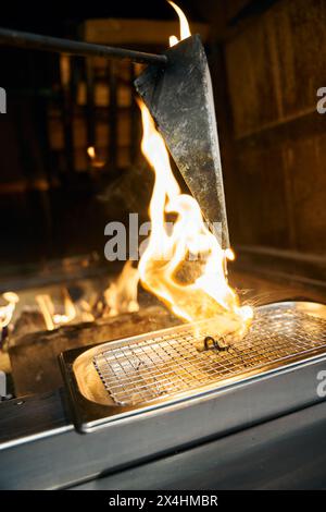 Flambe technique cooking of burning iron triangle pot frying oyster in ...