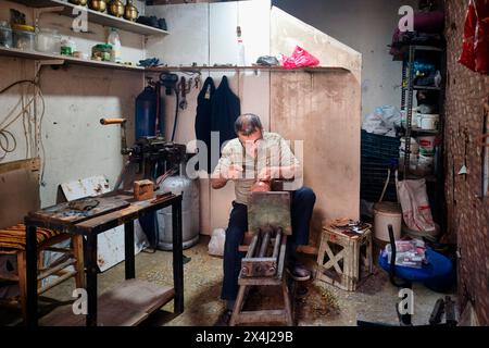 Coppersmith at work engraving a copper plate, Gaziantep bazaar, Turkey ...
