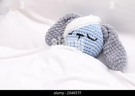 Toy cute bunny with bandage under blanket in bed Stock Photo - Alamy