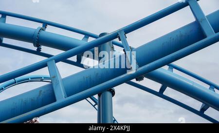 Two blue-colloured roller coaster tracks crossing each other, at the ...