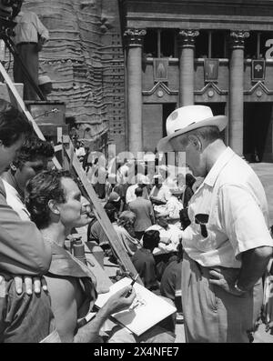 WILLIAM WYLER looks at a drawing made by CHARLTON HESTON during a break ...