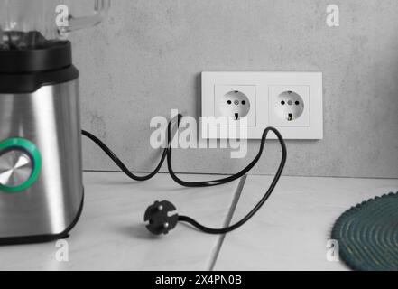 Power sockets and blender on white table Stock Photo - Alamy