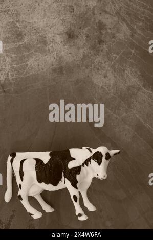 Plastic toy cow in front of world model background. Cows breeding and ...