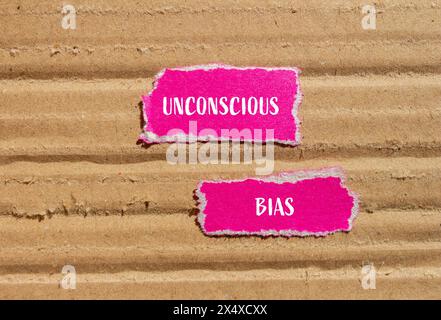 Unconscious bias words written on ripped paper with orange background. Conceptual unconscious ...