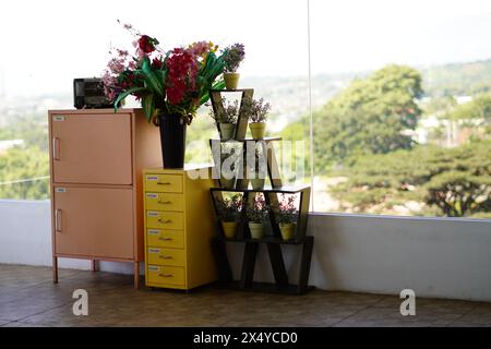 A small, colorful cupboard that decorates a room with fake flowers ...