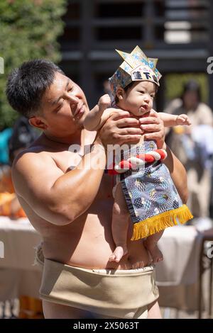 Yokohama, Japan. 05th May, 2024. Baby looks at a dragon's mask during ...