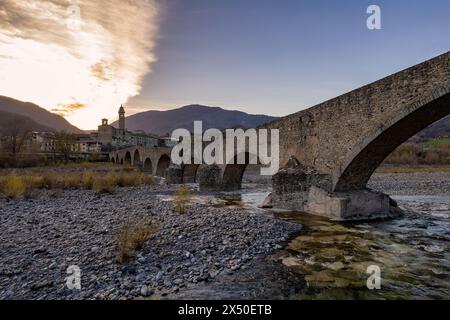 Aerial view of Bobbio and Devil's Bridge at sunset, Trebbia Valley ...