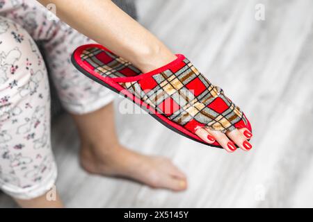 a man stuck his finger into a hole in a sneaker. old slipper. holey ...