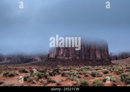 Low rainclouds hug a butte in Monument Valley's Navajo Tribal Park as ...