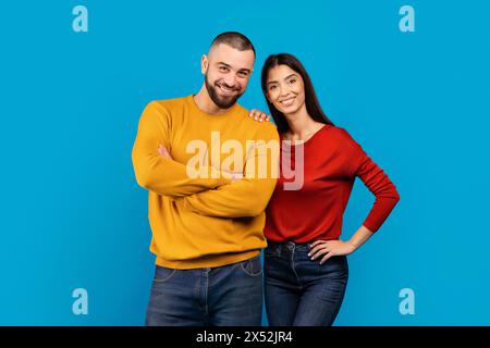 Picture of joyful couple man and woman 30s using mobile phone while ...