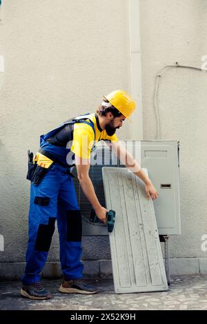 Qualified repairman starting work on faulty air conditioner, using ...