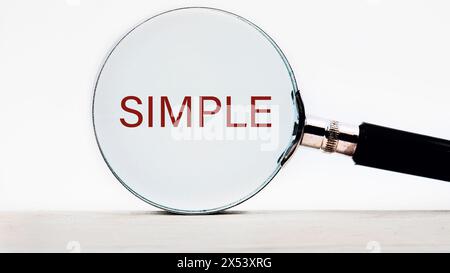SIMPLE word text appeared through a magnifying glass on a black ...