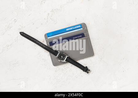 Watches, grey credit holder with cards and driver's license on light ...