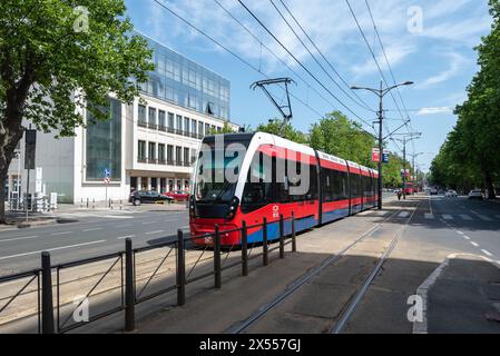 Traditional red electric trams taking passengers around the streets of ...