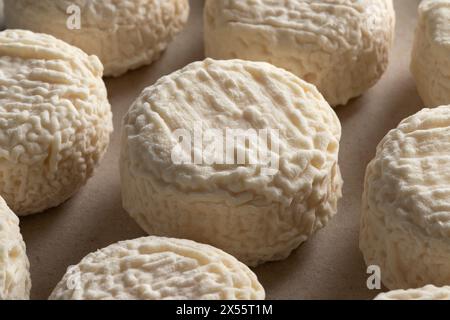 Group of fresh made French Crottin de chevre on wicker surface close up ...