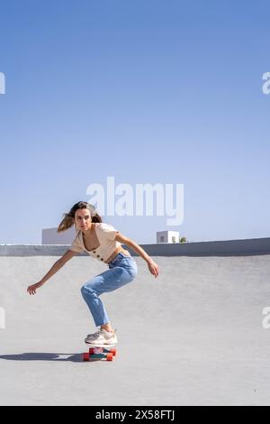 Confident female in trendy summer overall standing near old abandoned ...
