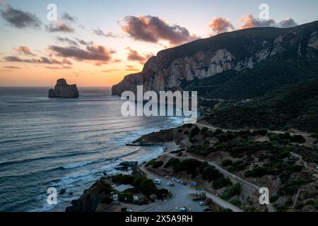 Sunset over a serene beach with a winding stream and distant islands ...