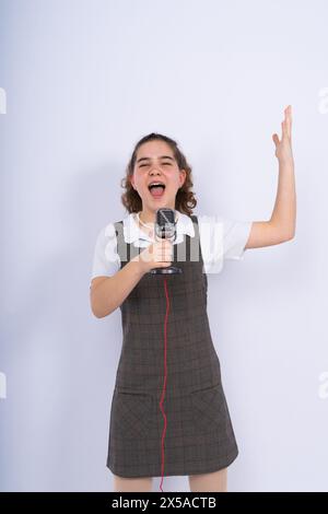 With microphone in hand positive teenage girl singer. young karaoke ...