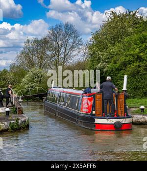 A traditional narrowboat entering the top lock at Caen Hill Locks ...