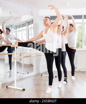 Group of dancers doing stretching at barre Stock Photo - Alamy