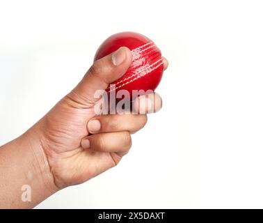 red cricket leather ball in bowler hand on the white background Stock ...