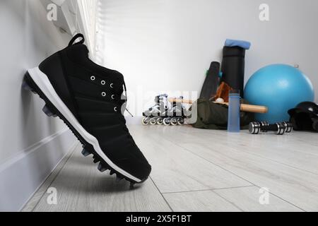 Black snickers and different sports equipment indoors Stock Photo - Alamy