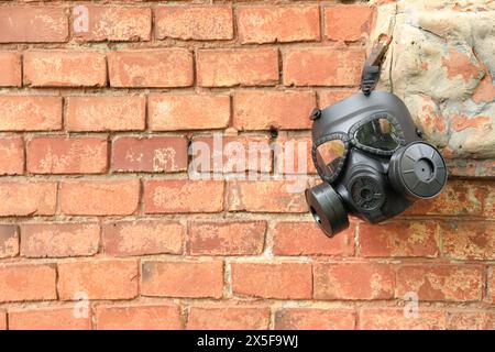 One gas mask hanging near brick wall on building Stock Photo - Alamy
