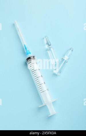 Ampoules with a medicine and a syringe on a light background ...