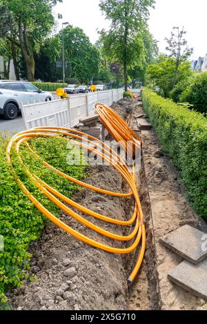 Verlegung von Glasfaserkabeln, Leerrohre werden unter einem Gehweg ...