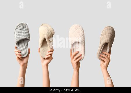 Female hands holding slippers on beige background Stock Photo - Alamy