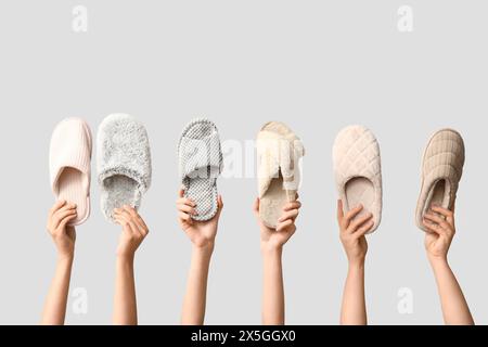 Female hands holding different slippers on white background Stock Photo ...