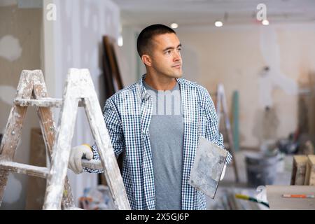 Portrait of man with float trowel in building site Stock Photo - Alamy