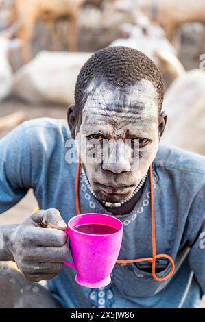 Dust covered man drinking local coffee, Mundari tribe, South Sudan ...