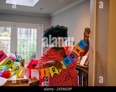 Woman hanging happy birthday banner Stock Photo - Alamy
